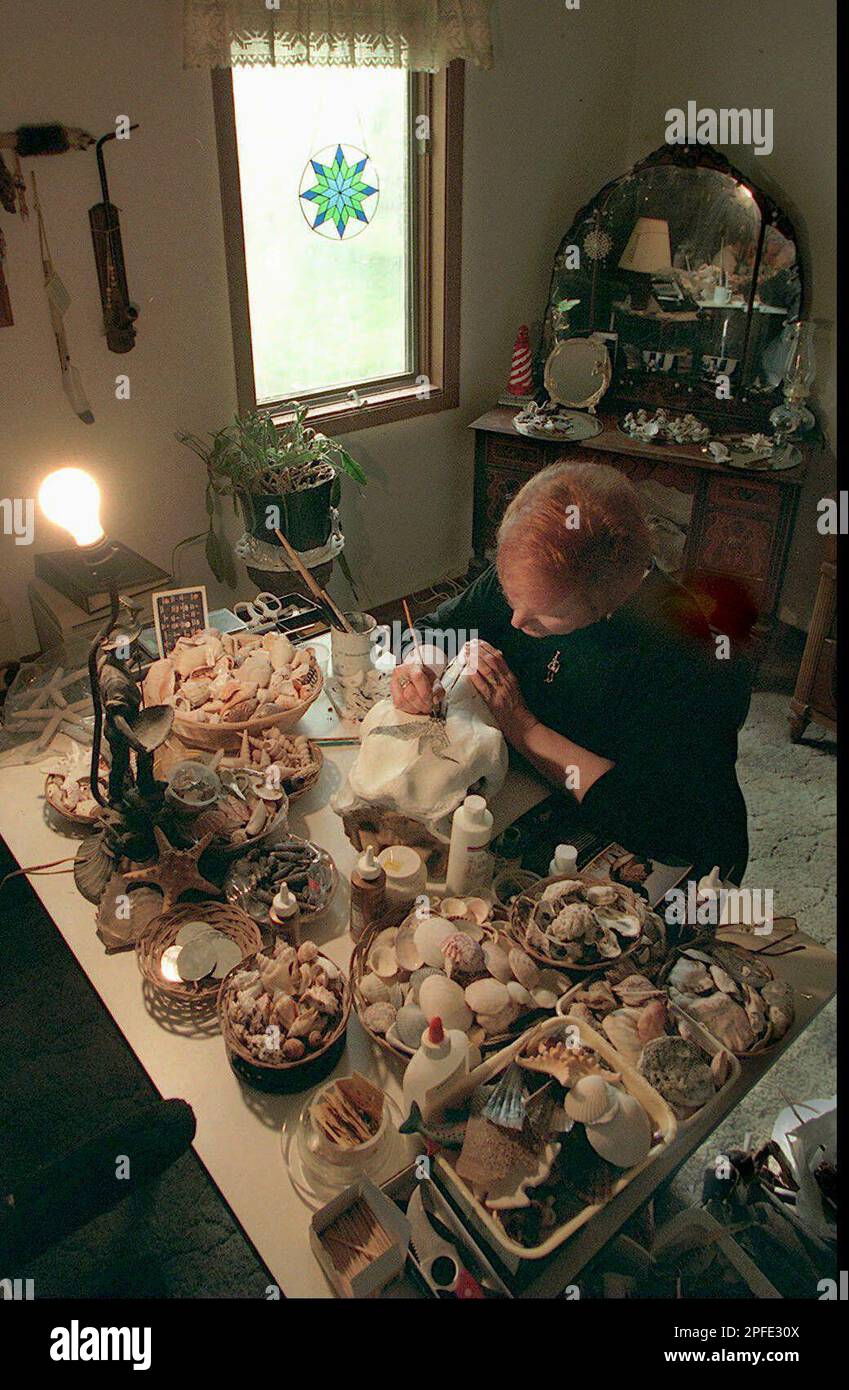 P. Jean Mathis, surrounded by shells, brushes, paints and other ...