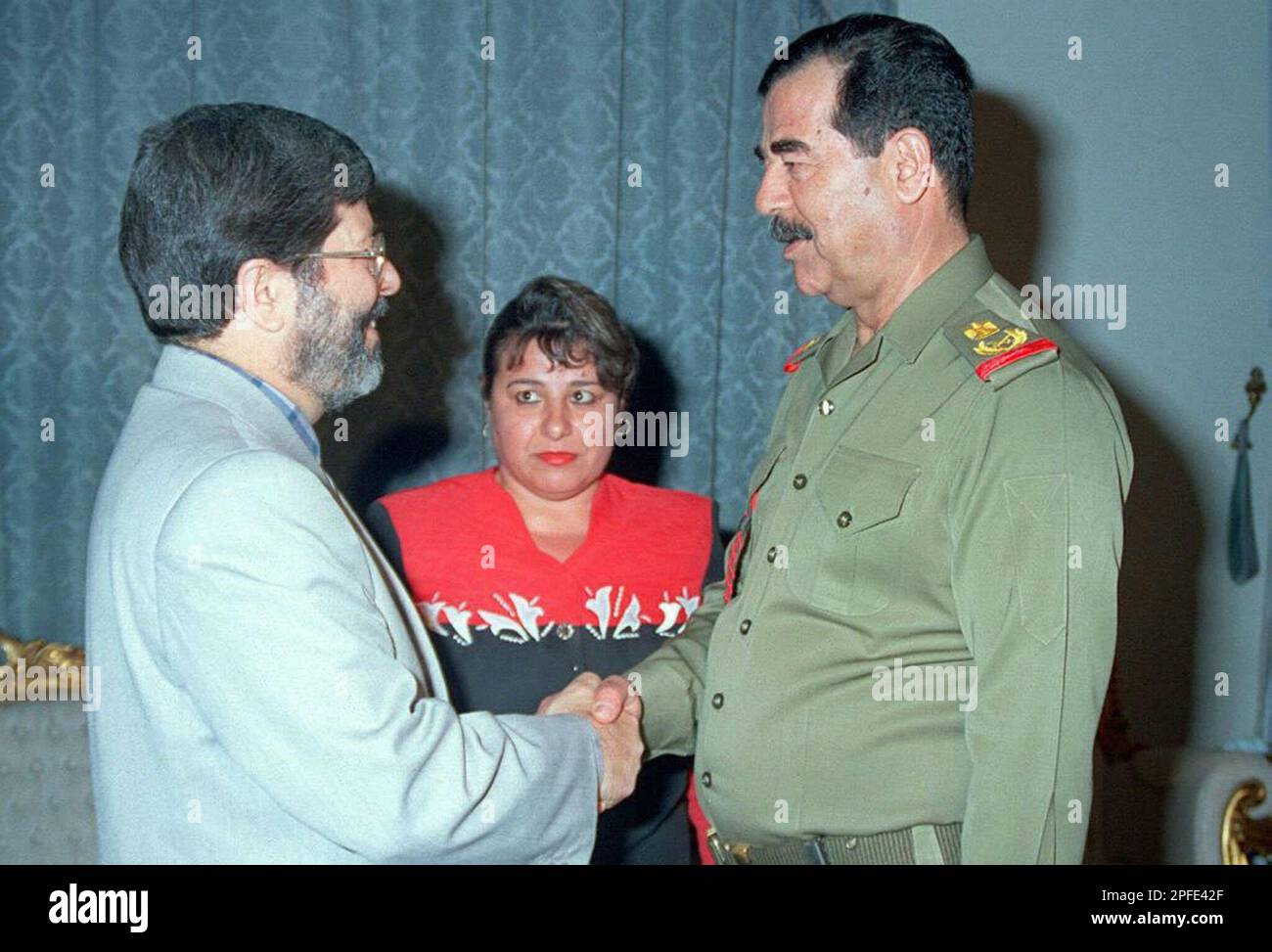 Iraqi president Saddam Hussein, right,shakes hands with Iranian health ...