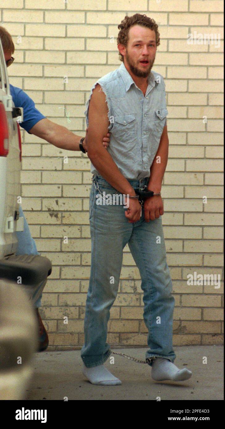 With his hands cuffed and feet chained, Chevie Kehoe is escorted into ...