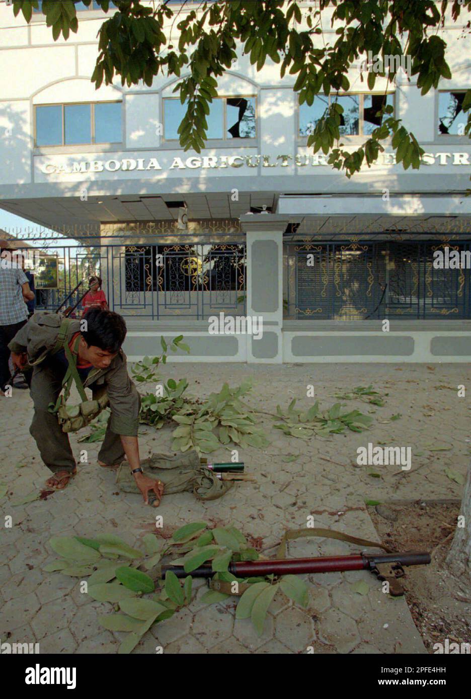 A Cambodian government soldier inspects a grenade launcher used last ...