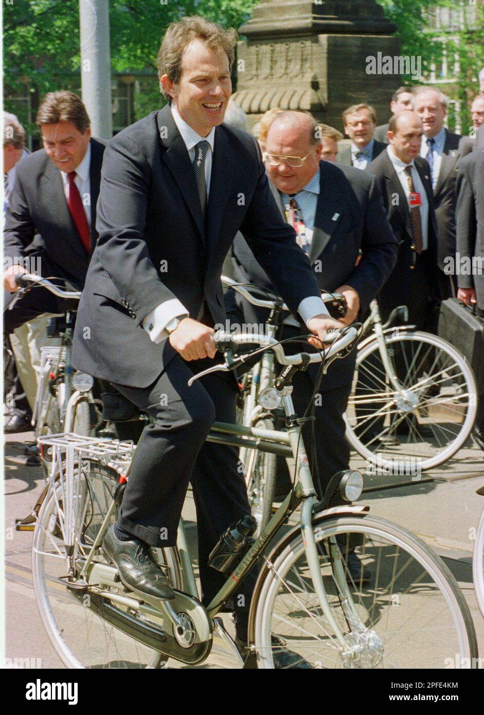 British Prime Minister Tony Blair rides his bike across a bridge ...