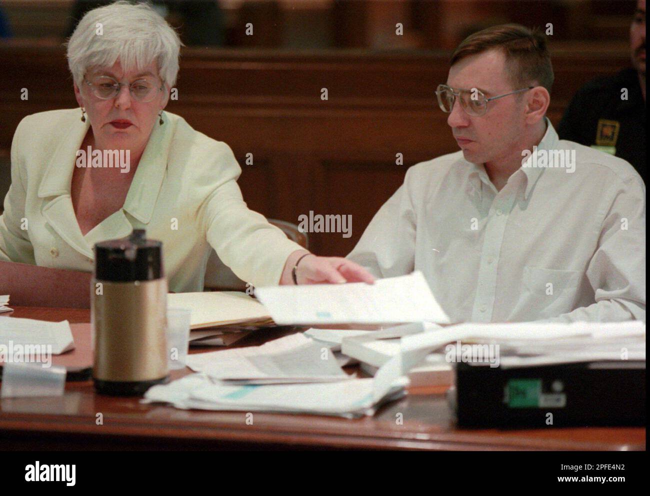 Defense attorney Barbara Lependorf sorts papers in front of client ...