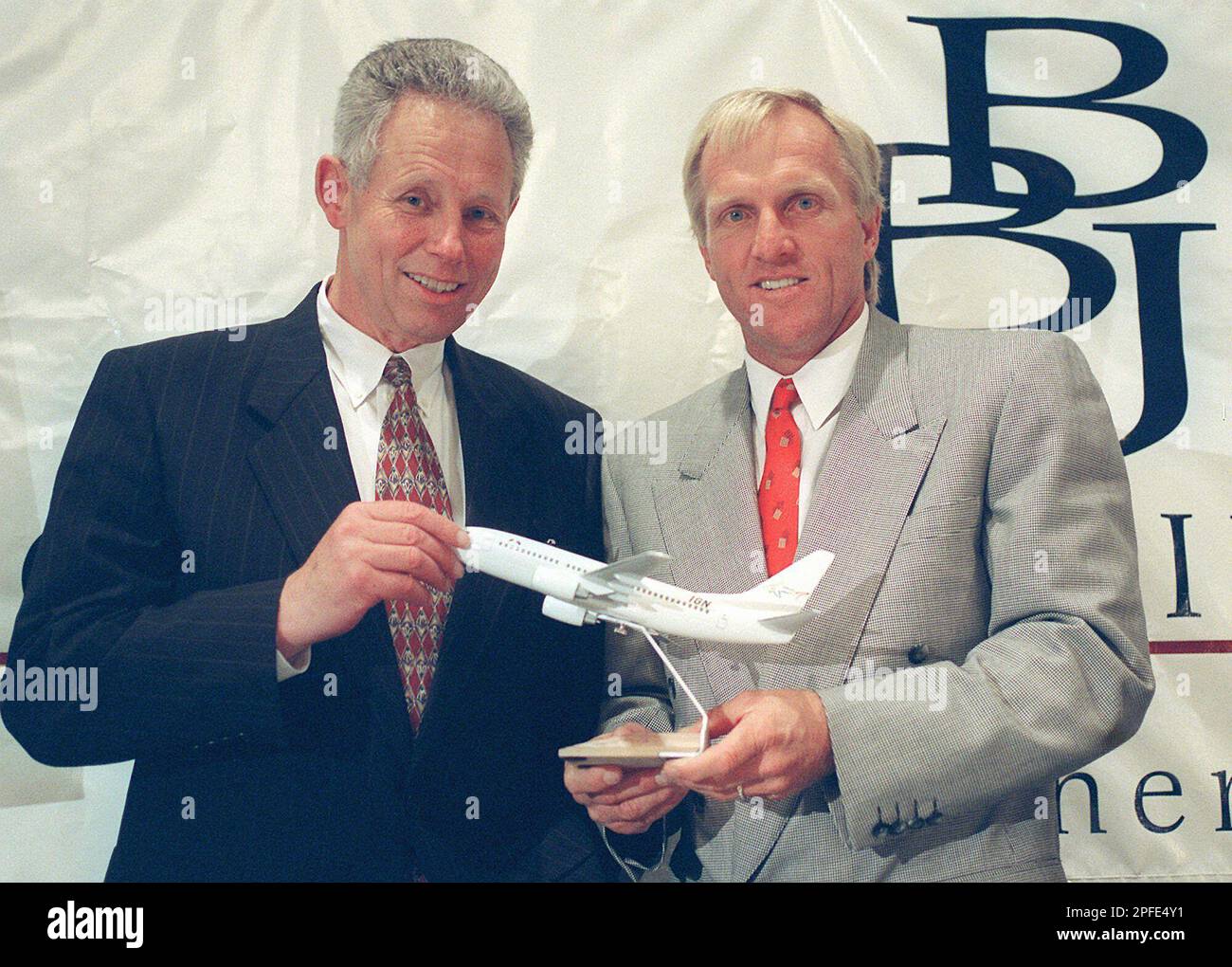 Golfer Greg Norman, right, accepts a model of a Boeing 737 business jet ...
