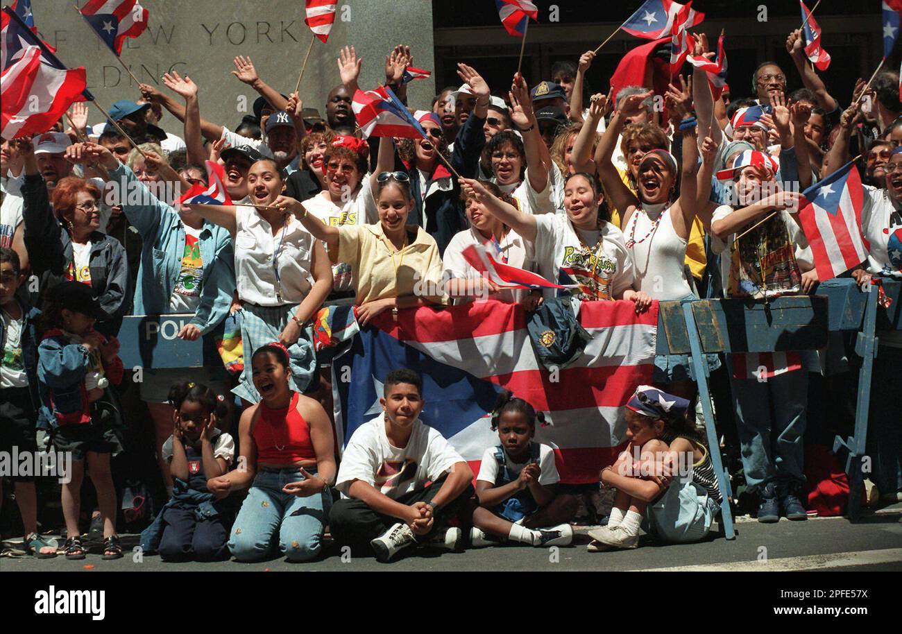 Spectators wave flags on New York's Fifth Avenue during the Puerto ...