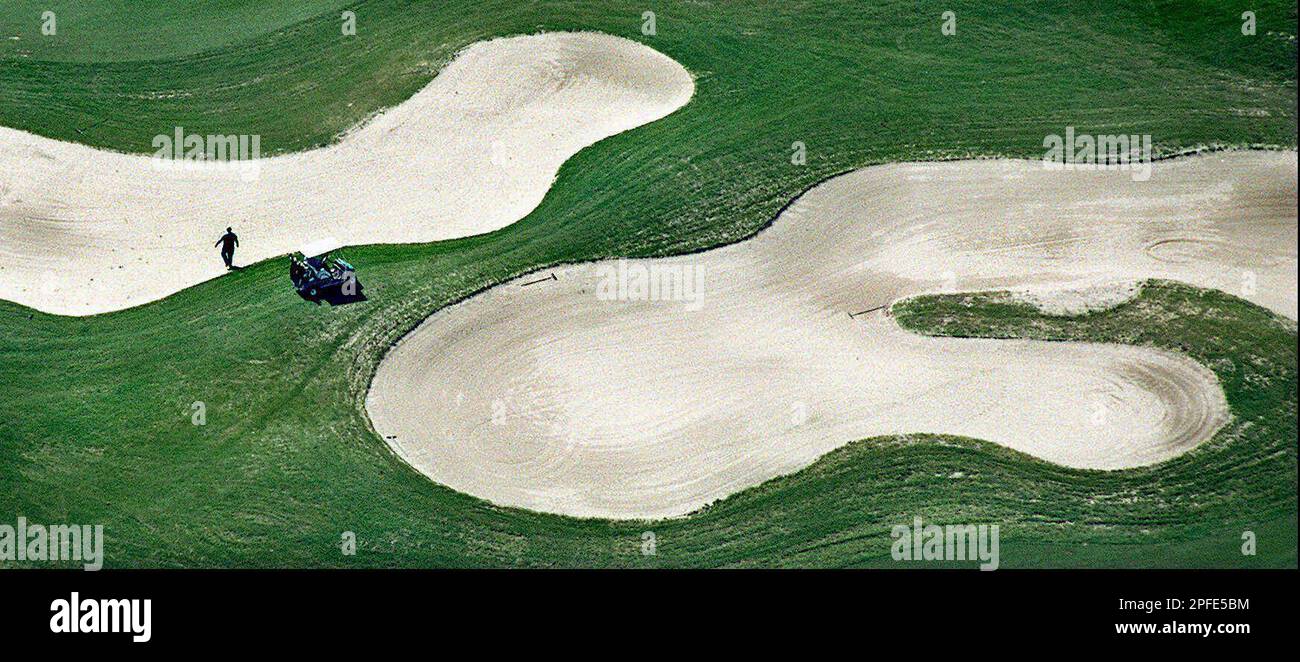 A golfer walks Tuesday, June 3, 1997, into one of the sand traps to retrieve his drive at the ...