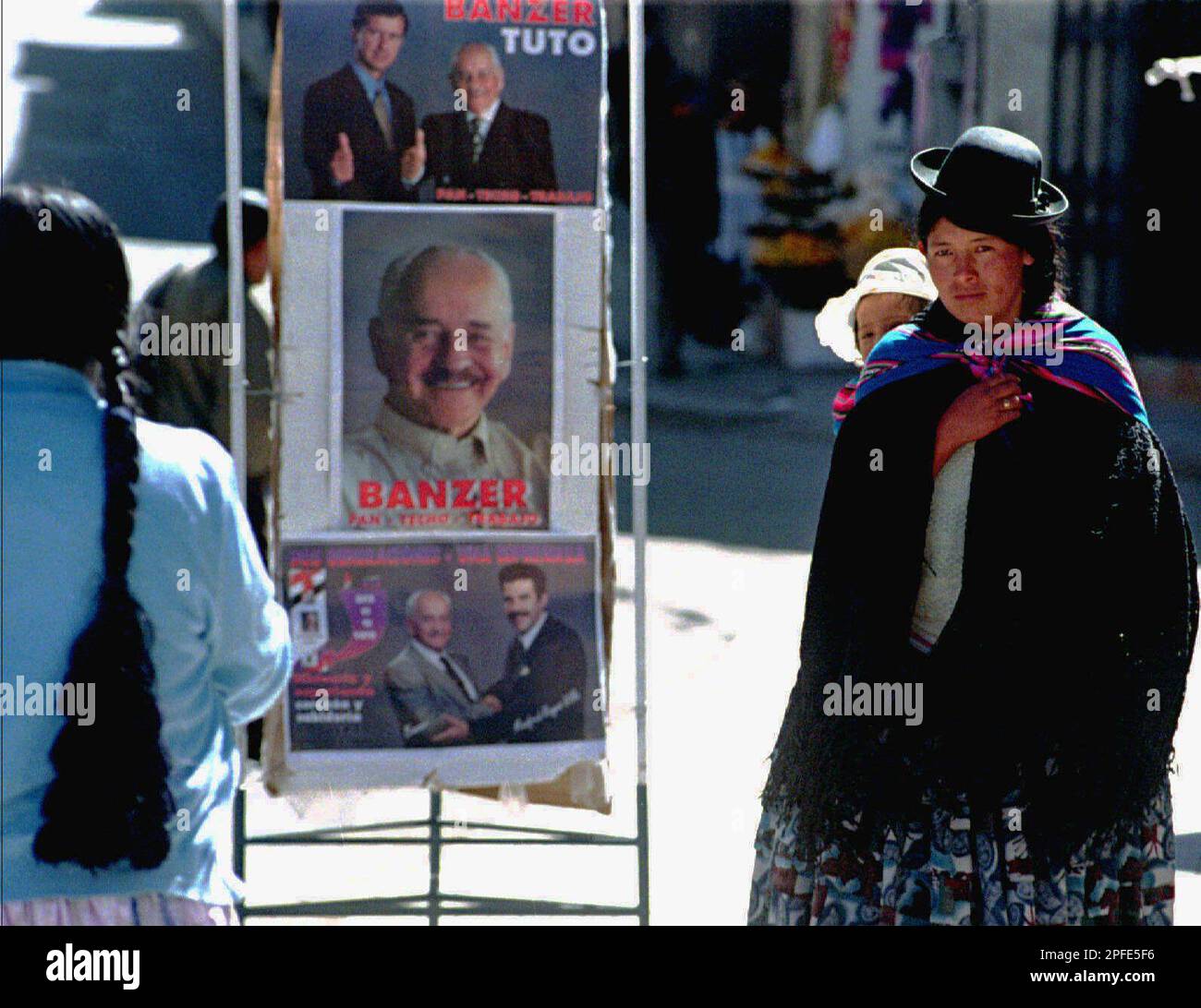 An Indian woman passes a campaign poster for Hugo Banzer Suarez on a ...