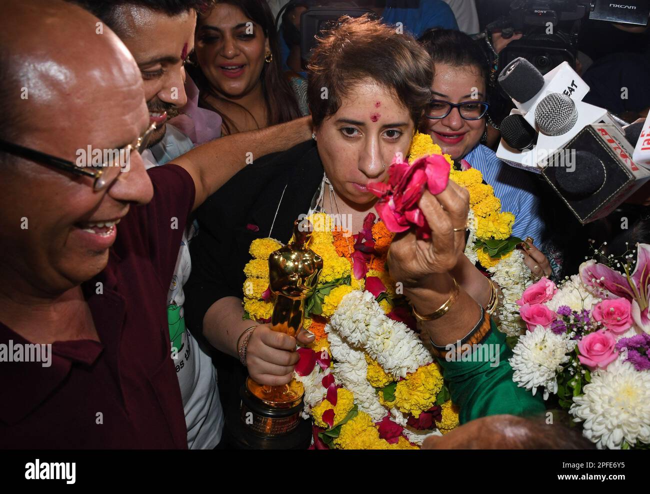 Mumbai, India. 17th Mar, 2023. Family members shower rose petals on ...