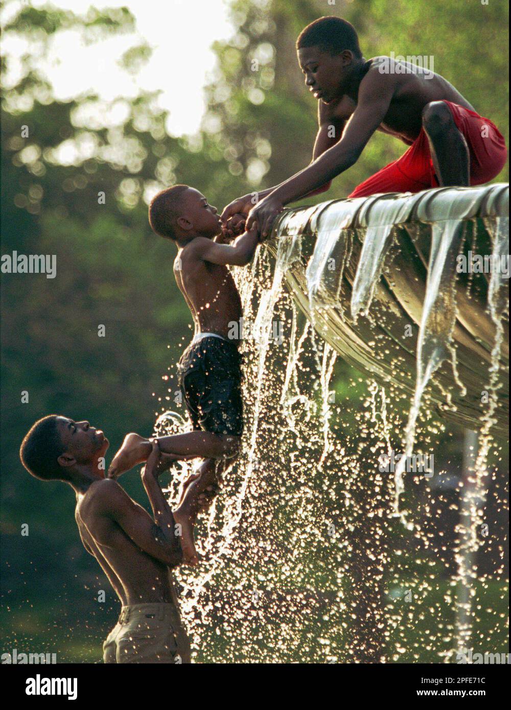 Helping their brother, Andrew Williams, climb onto Eakins Oval fountain ...