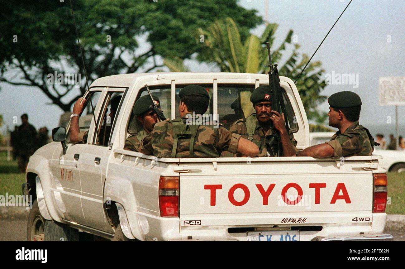 FILE -- Armed troops drive through the streets of Suva, Fiji, during ...