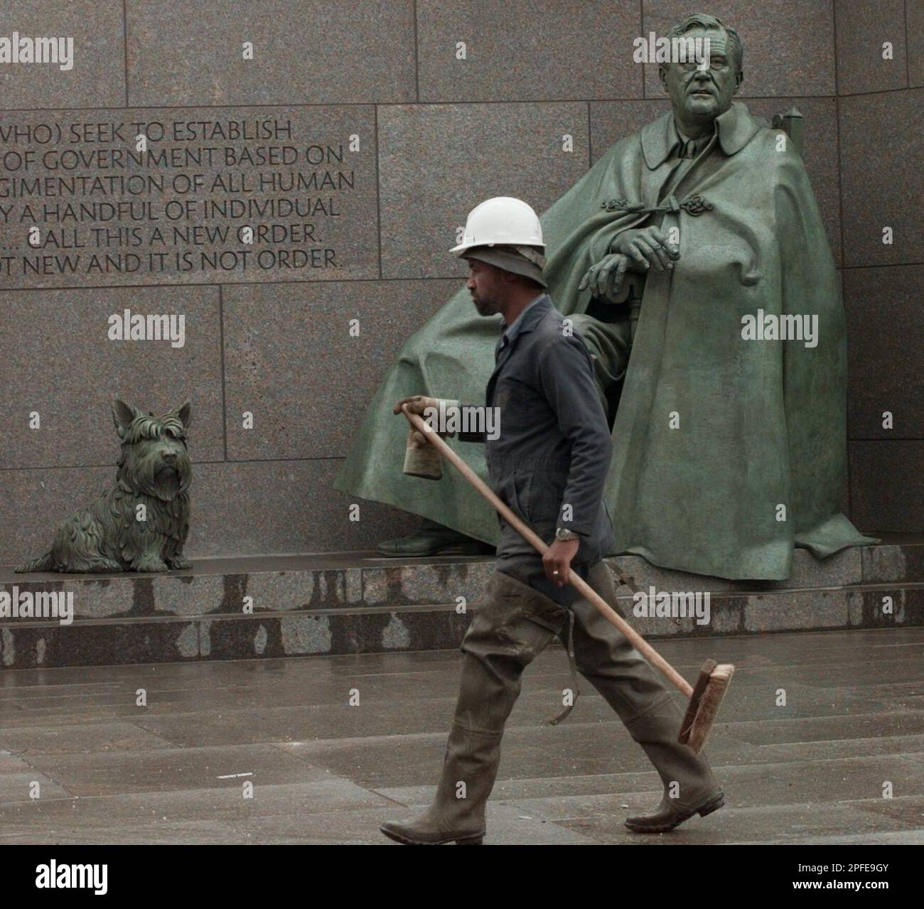 An unidentified worker walks past Neil Estern's statue of President ...