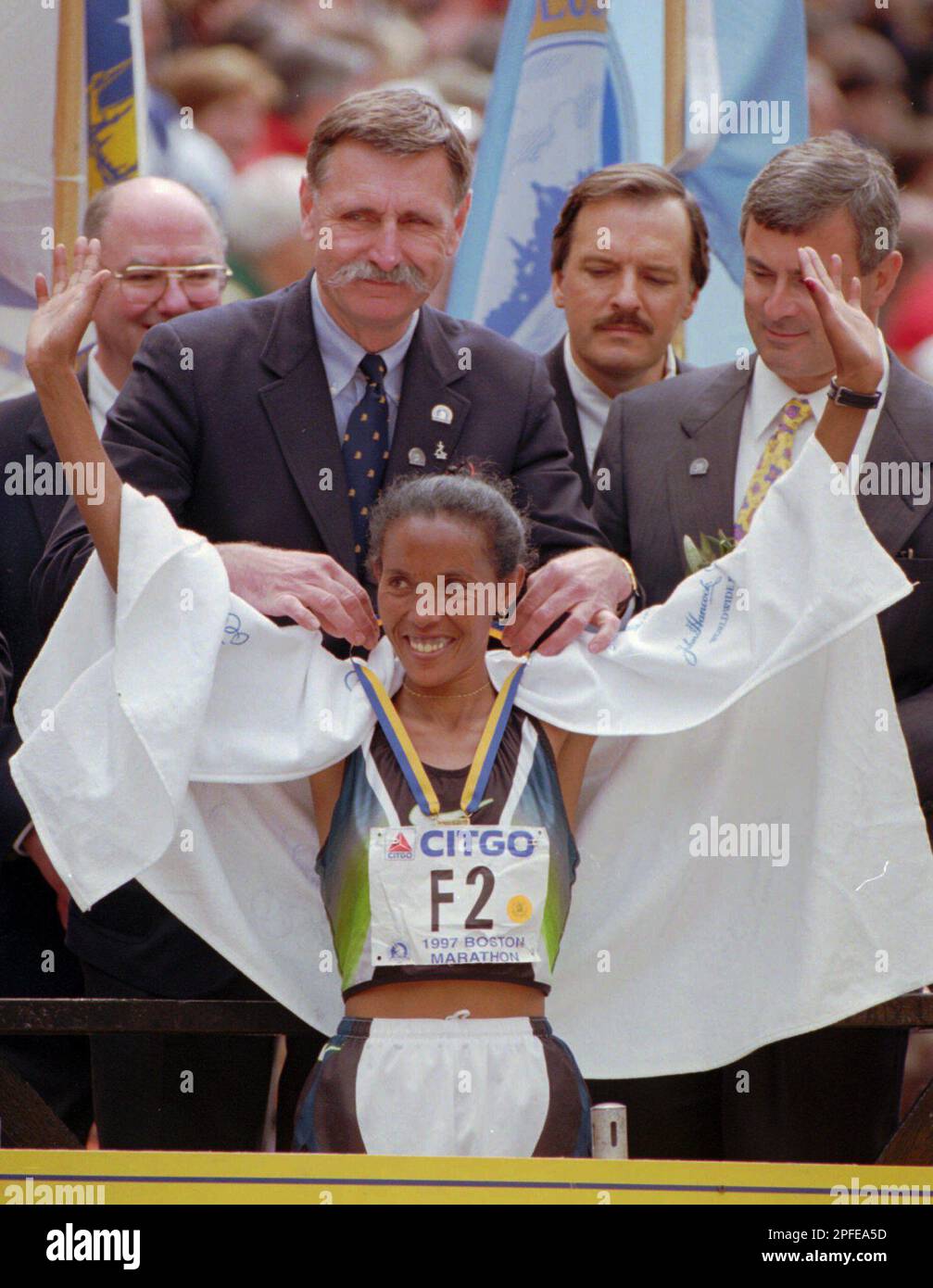 A Boston Marathon official places the winner's medal around the neck of ...