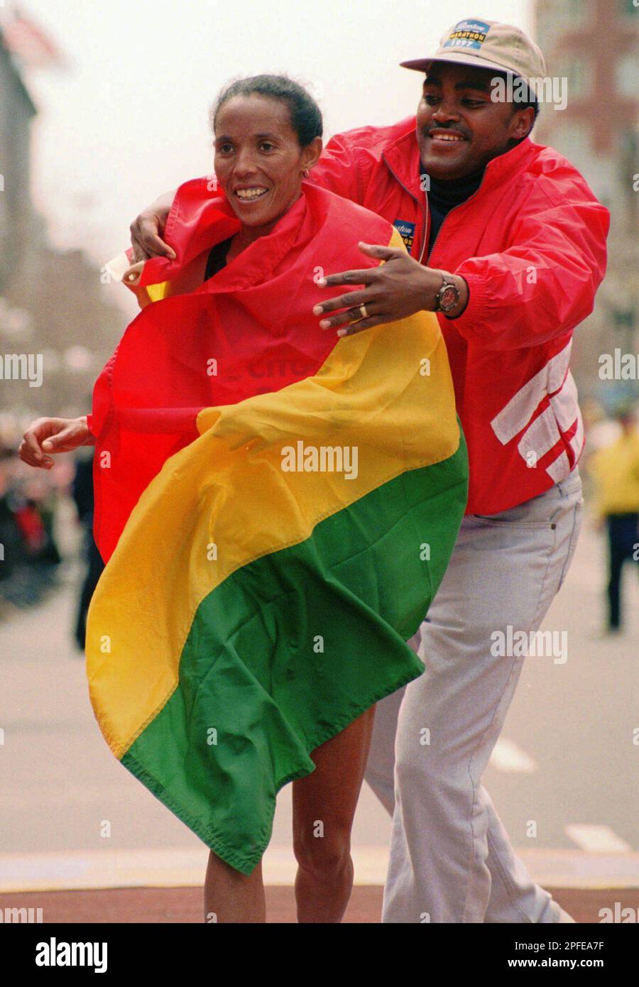 Fatuma Roba of Ethiopia has her country's flag wrapped around her by a ...