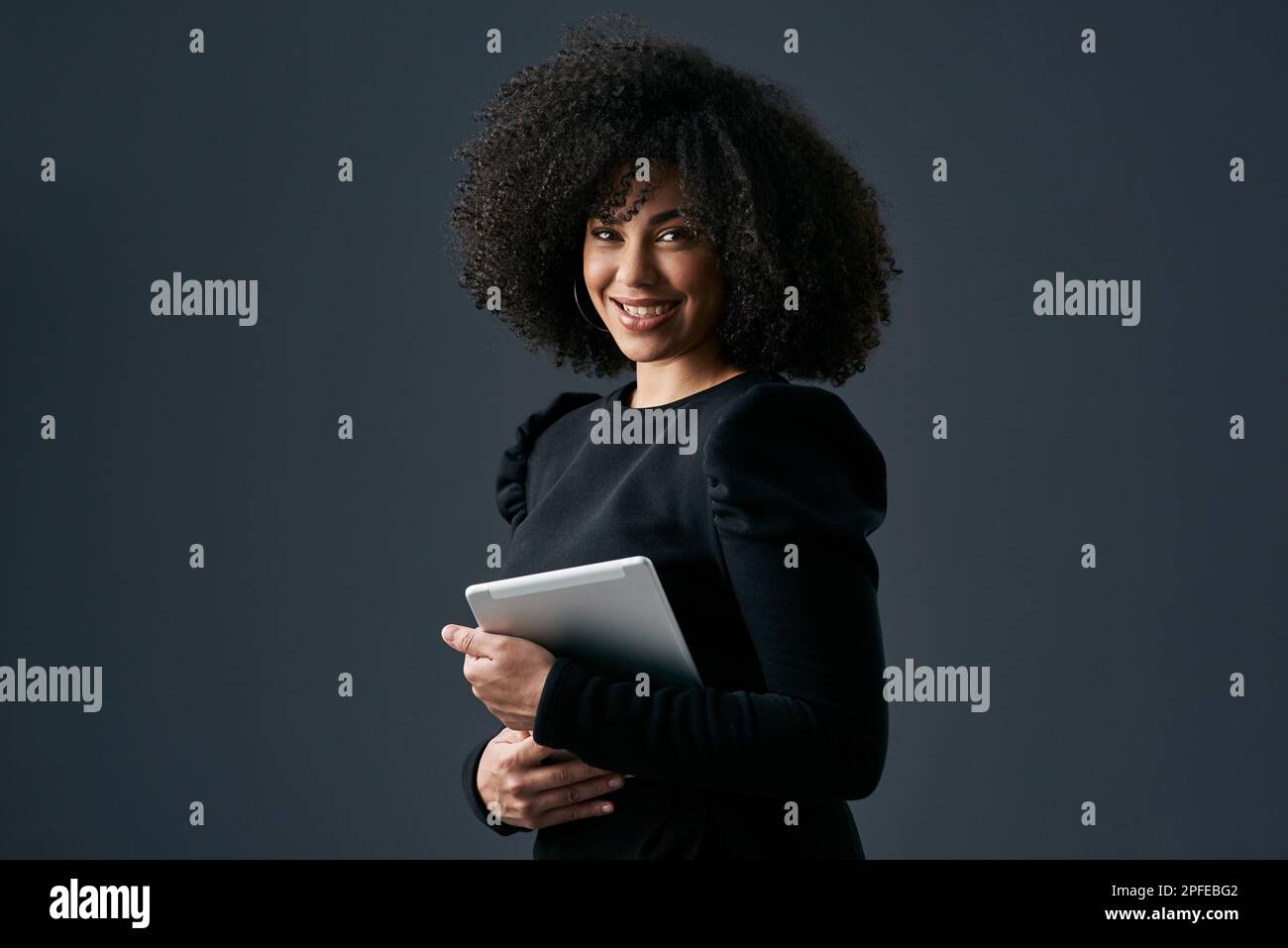 Keeping abreast of all the latest news. a young businesswoman using a ...