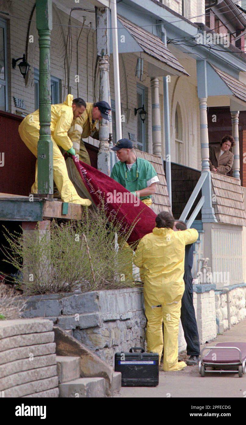 A neighbor of Ann Hoover watches as the Allegheny County Coroner ...