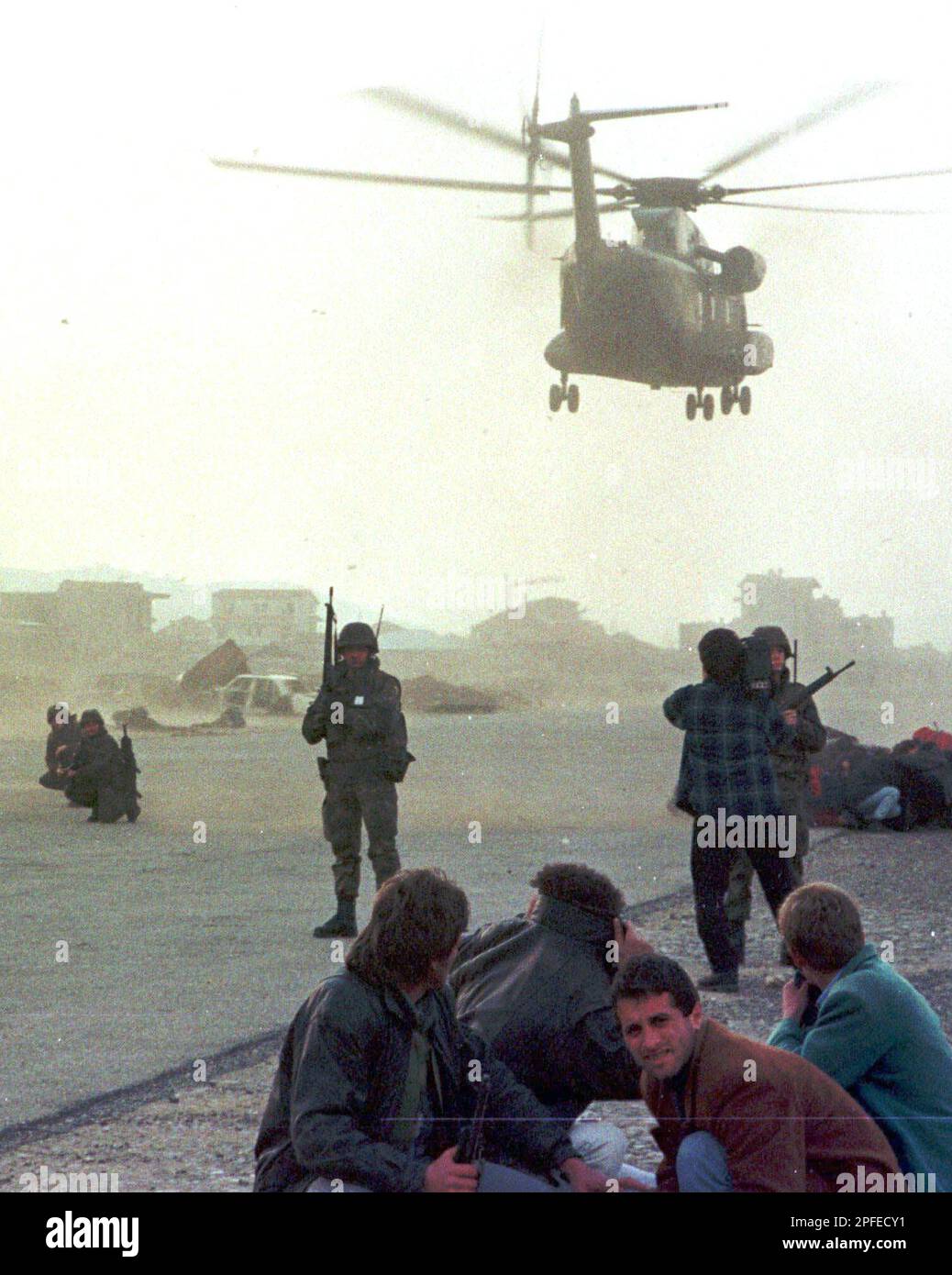 Unidentified people crouch down while German Bundeswehr soldiers and a ...
