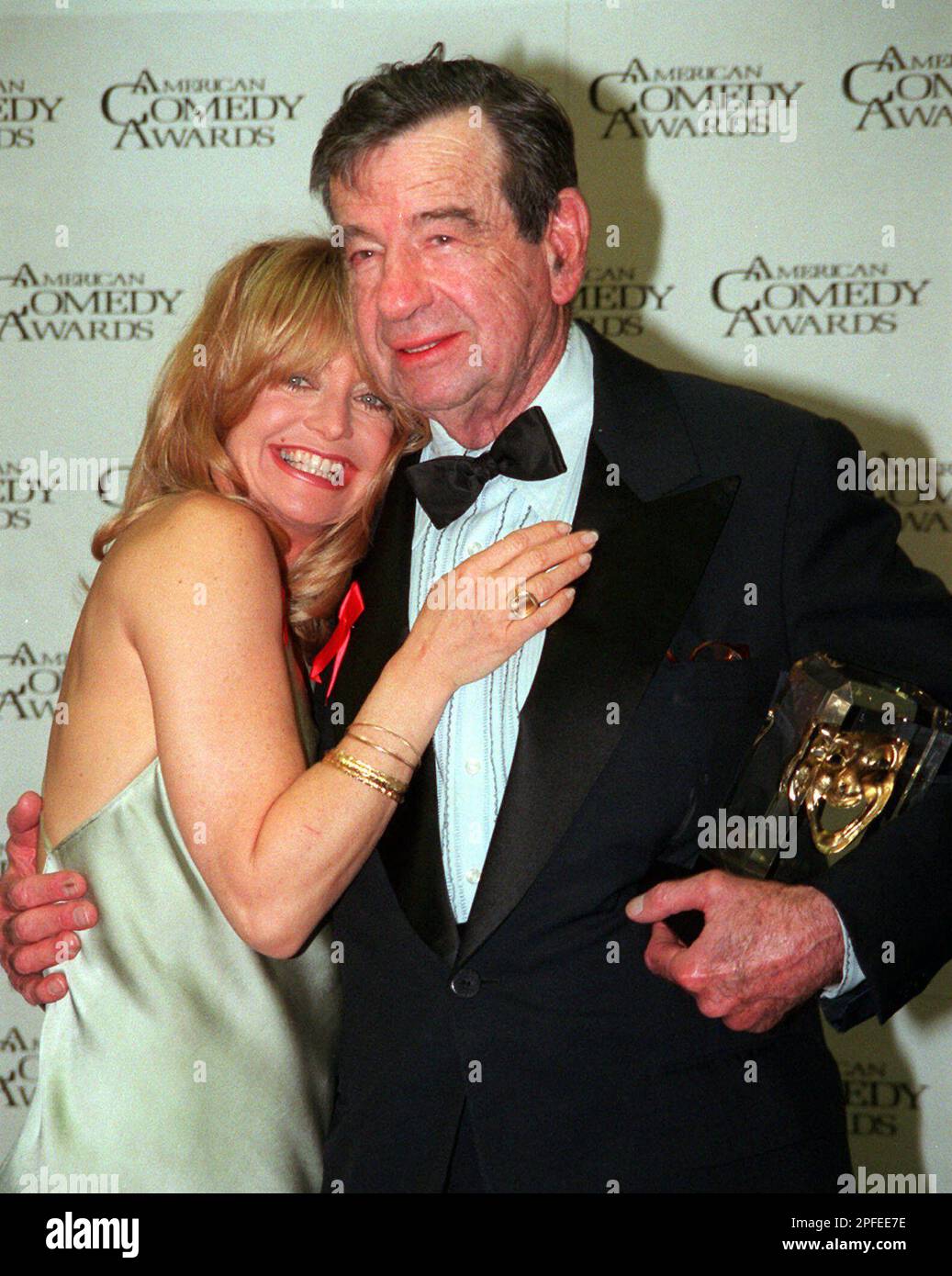Actress Goldie Hawn hugs actor Walter Matthau as he holds a Lifetime ...