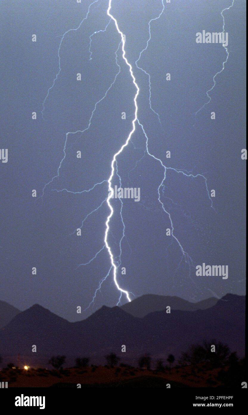 A bolt of lightning strikes behind the McDowell mountains in north ...