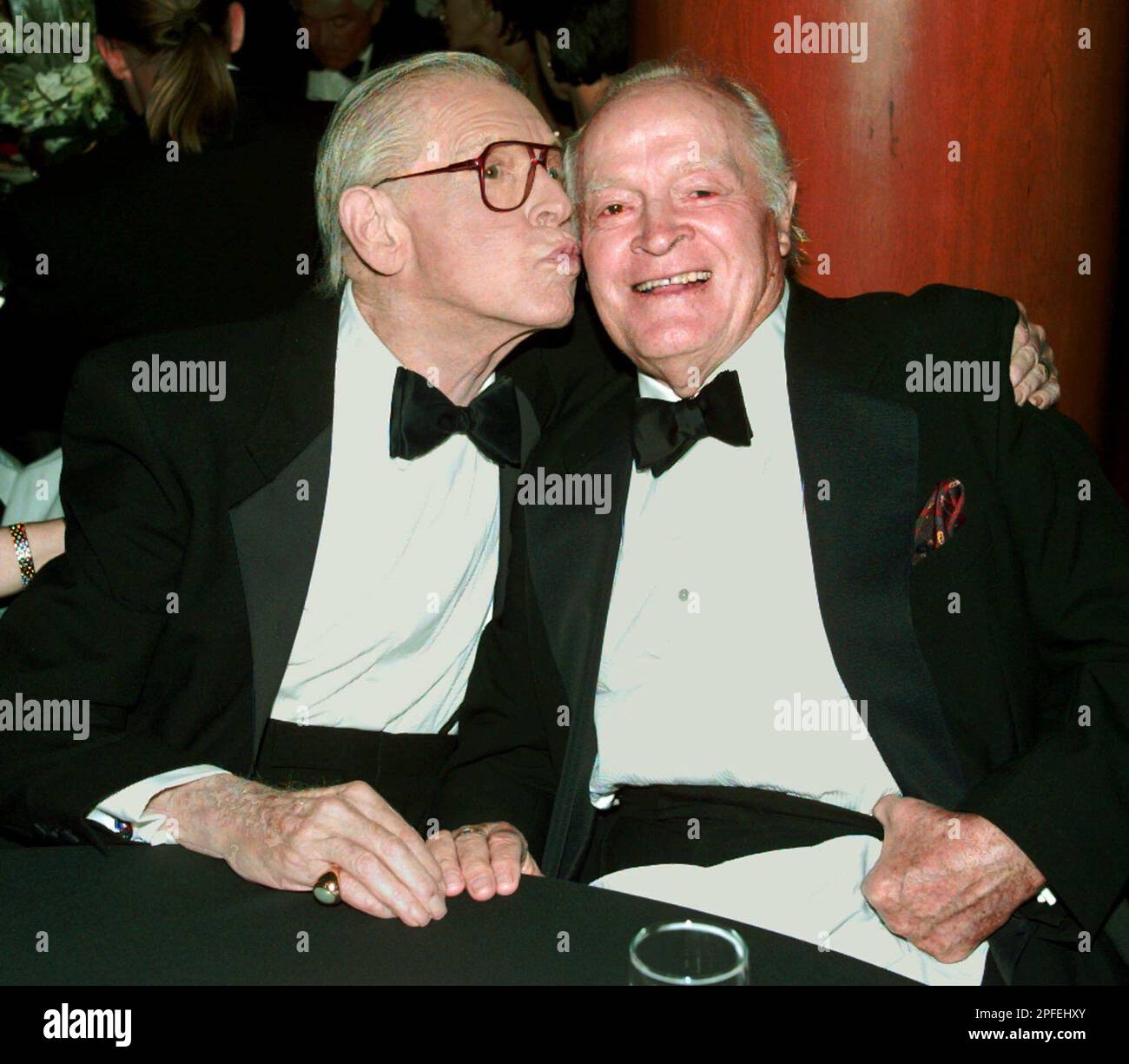 Milton Berle, left, gives Hollywood legend Bob Hope a kiss during a ...