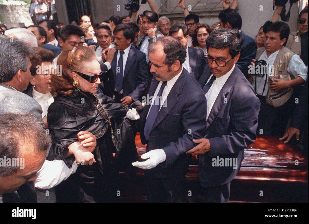 Movie star Maria Felix, left, is led by funeral attendants during the ...