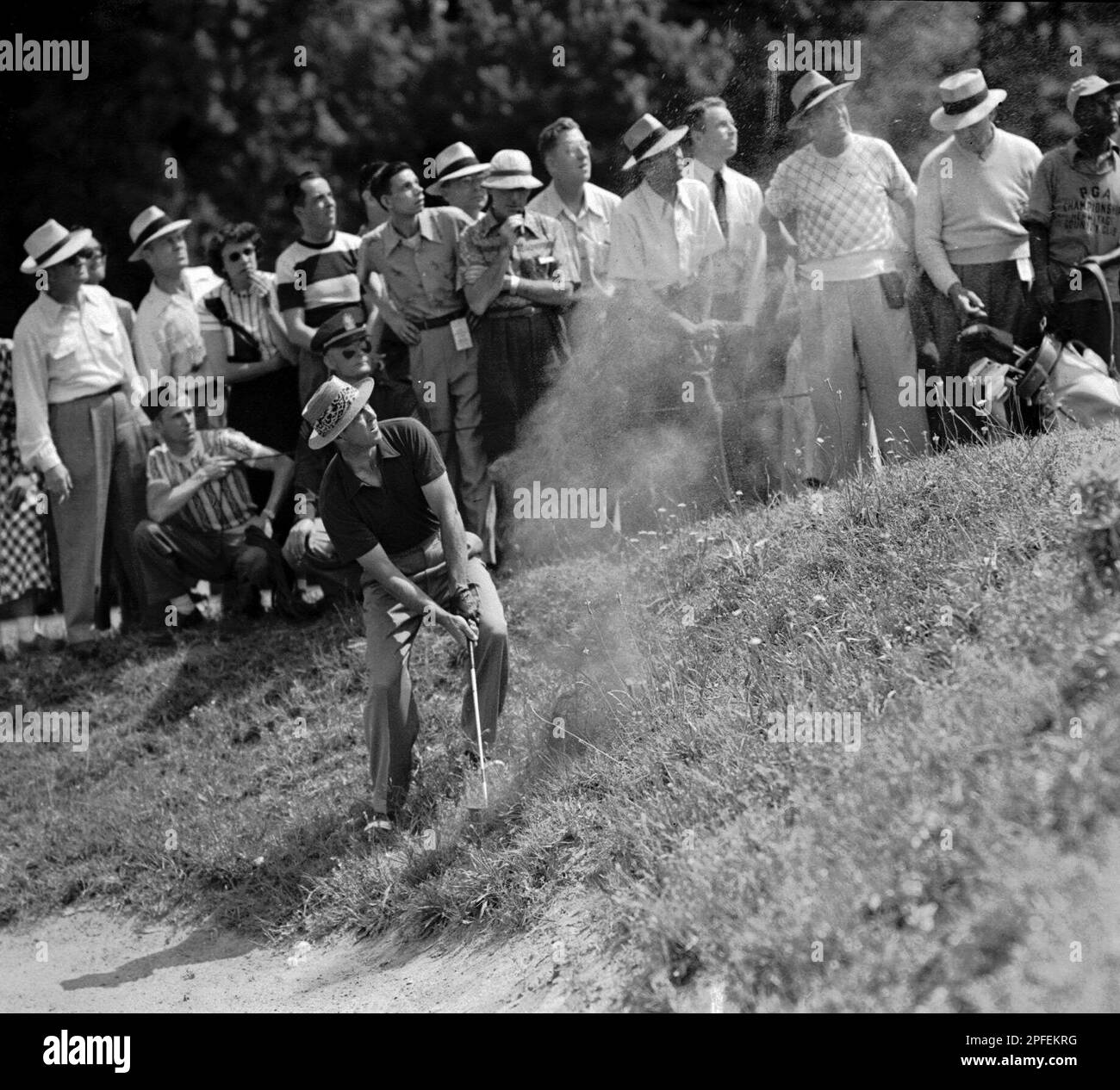 Sam Snead makes an iron shot from the site of a sand trap on the second ...