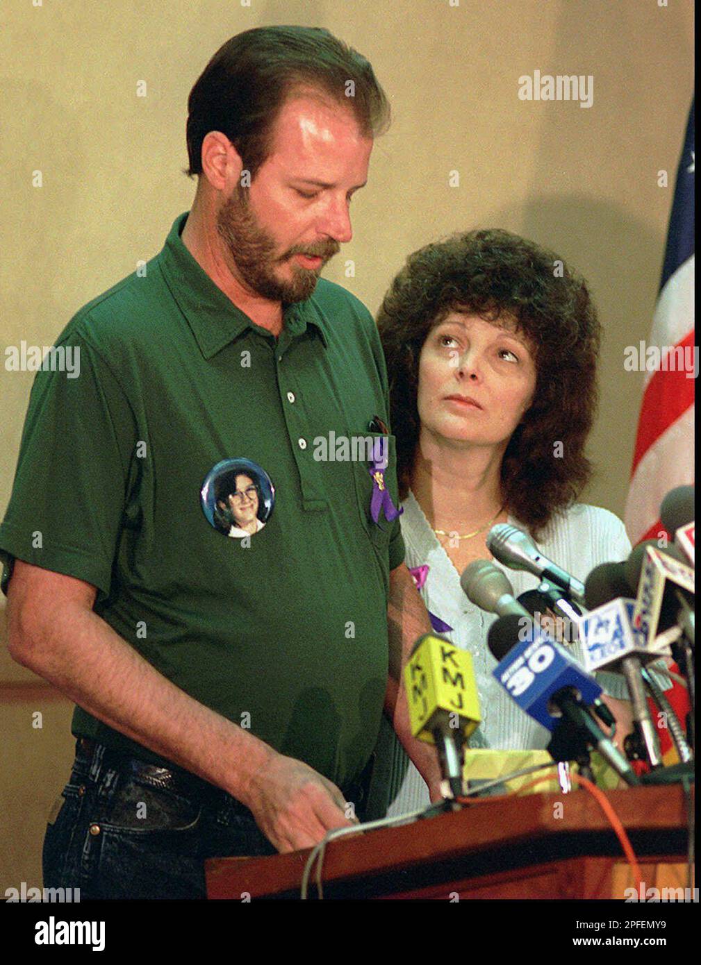 Chris Conrad, with his wife Terri, reads a statement to the media ...