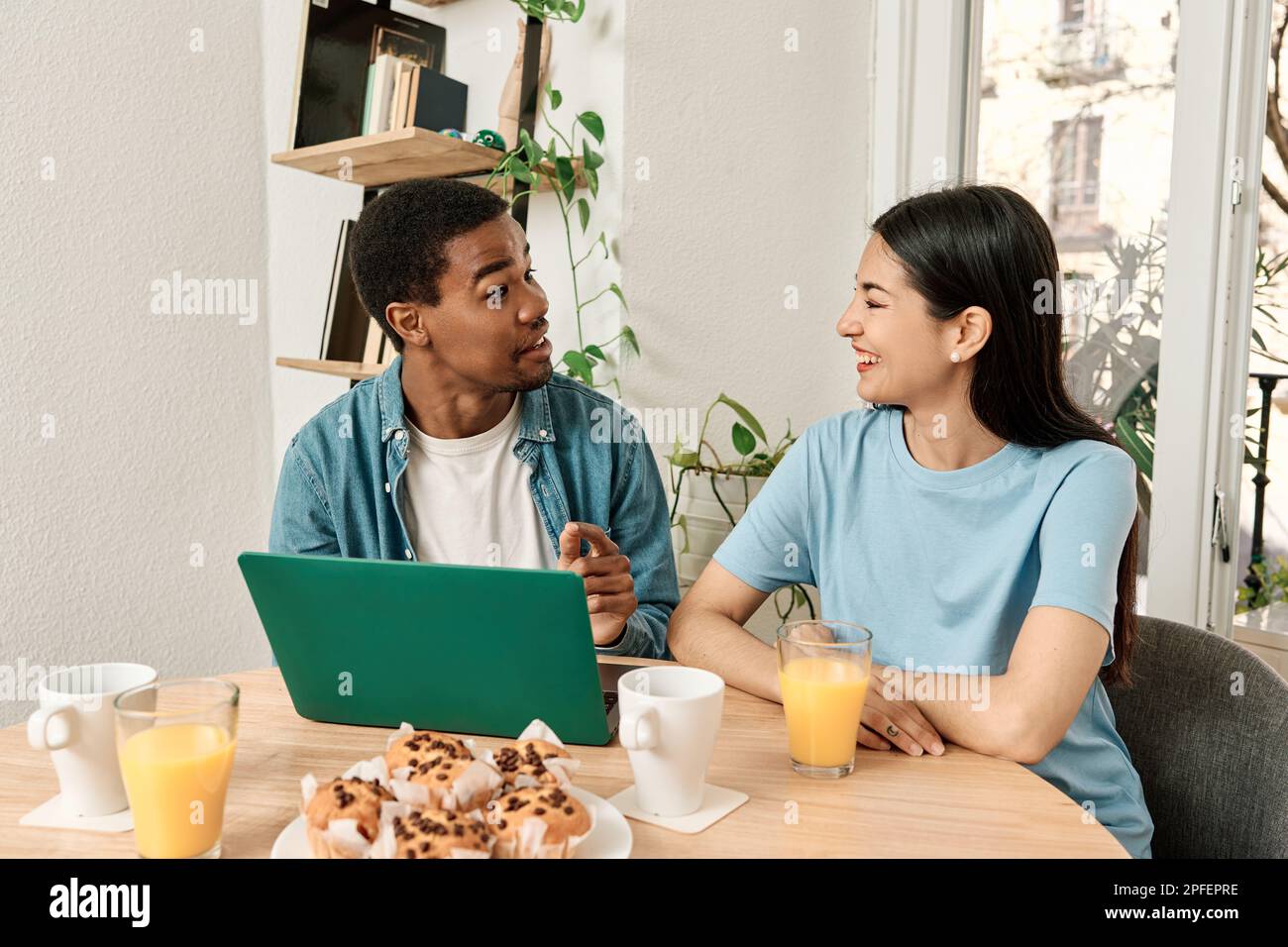 Friends using a laptop while eating at home Stock Photo - Alamy