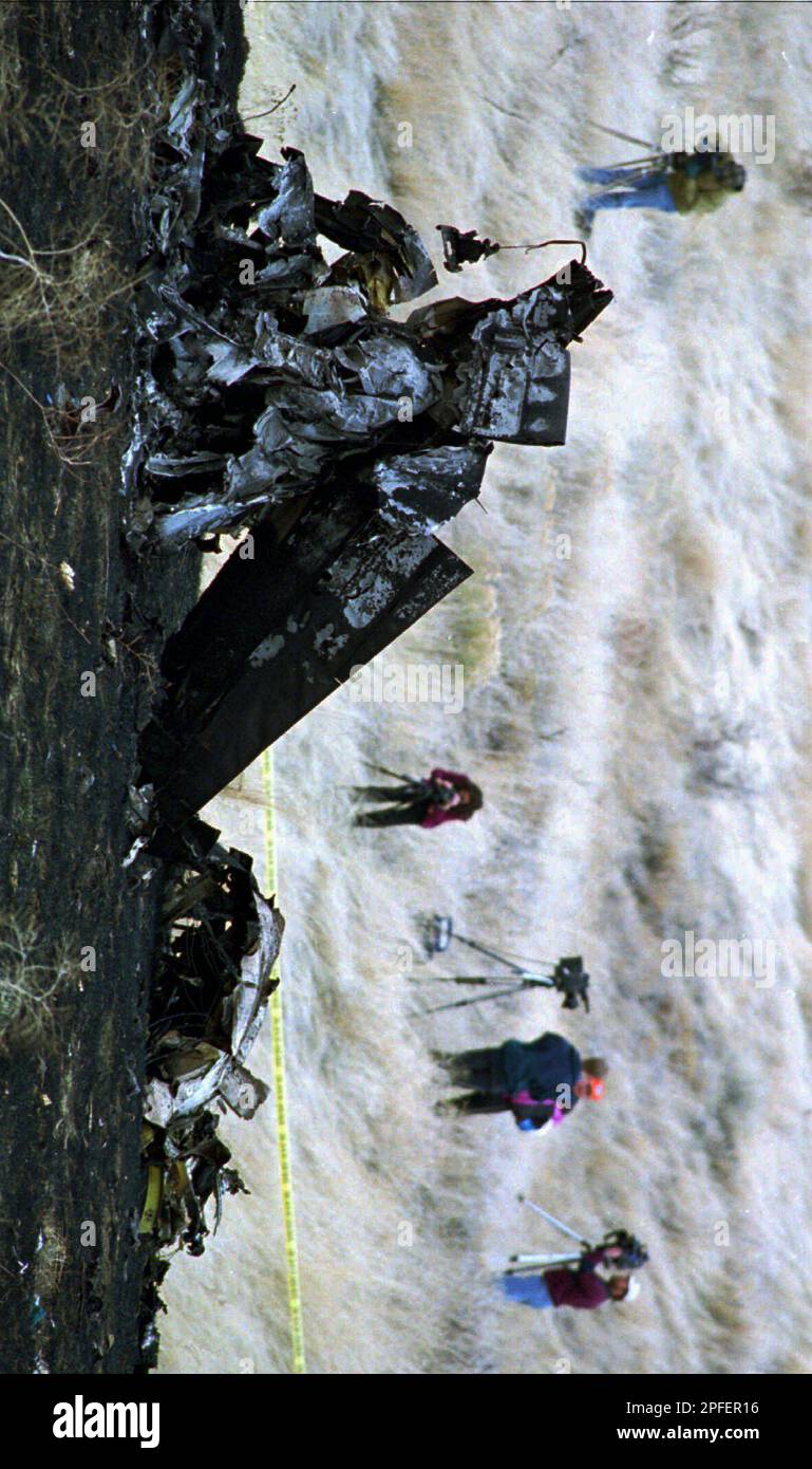 Media and security guards stand outside the crash site of a twin-engine ...