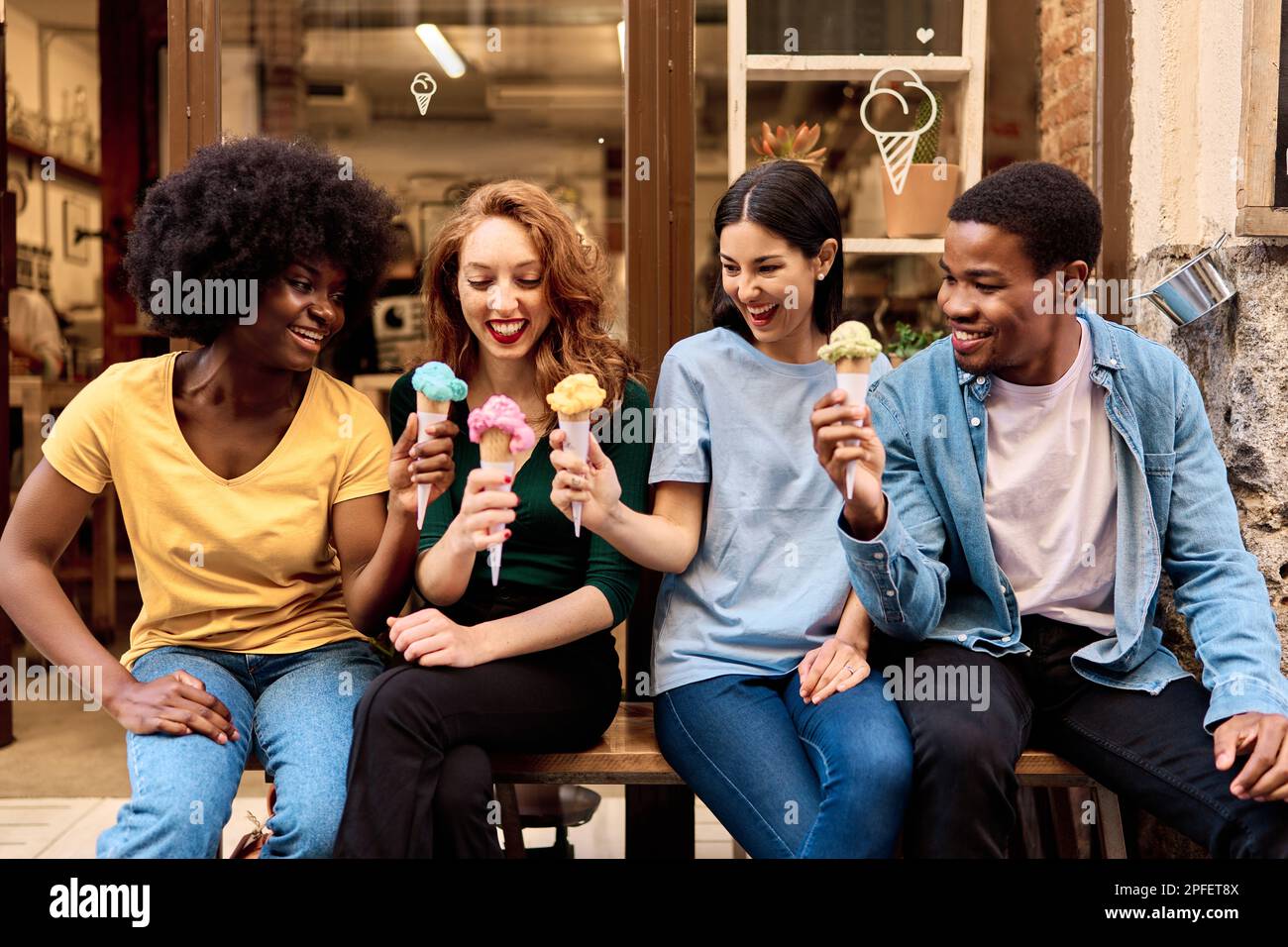 Multiethnic group of friends celebrating while eating ice cream ...