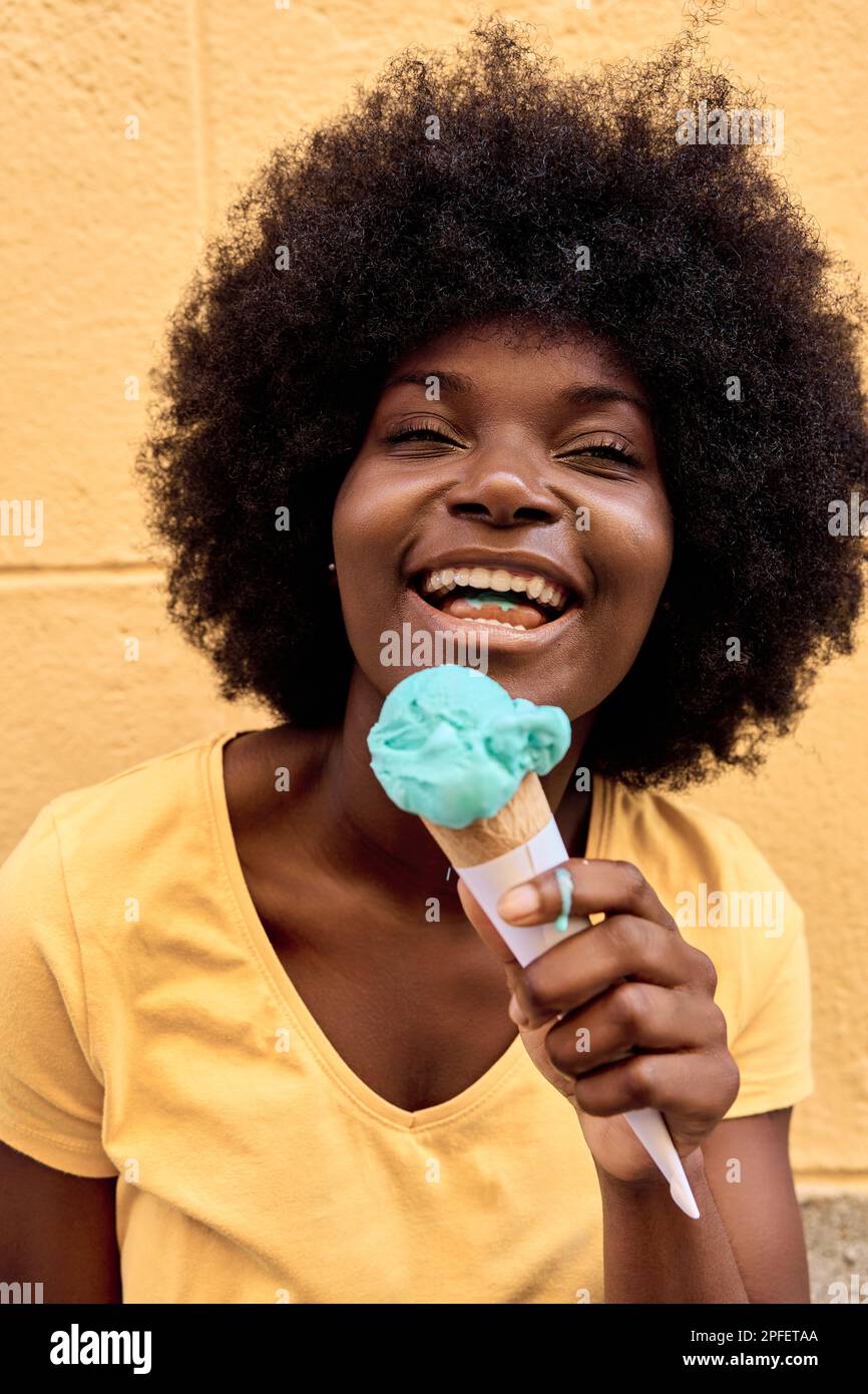 Happy african woman eating an ice cream Stock Photo - Alamy