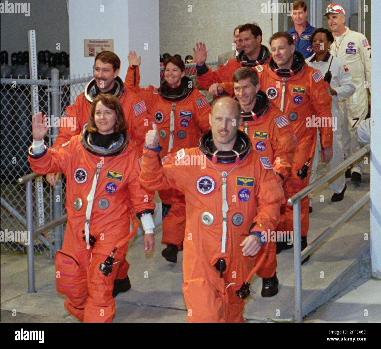 STS-73 Commander Ken Bowersox, left, gives photographers the thumbs up as he leads fellow crew ...