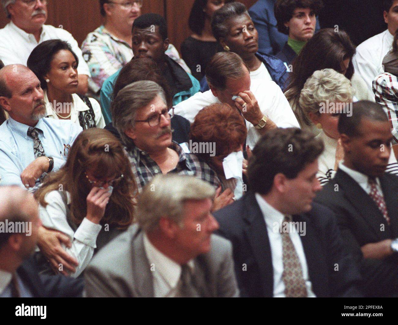 Fred Goldman, center with glasses, comforts his wife Patti, right, and ...