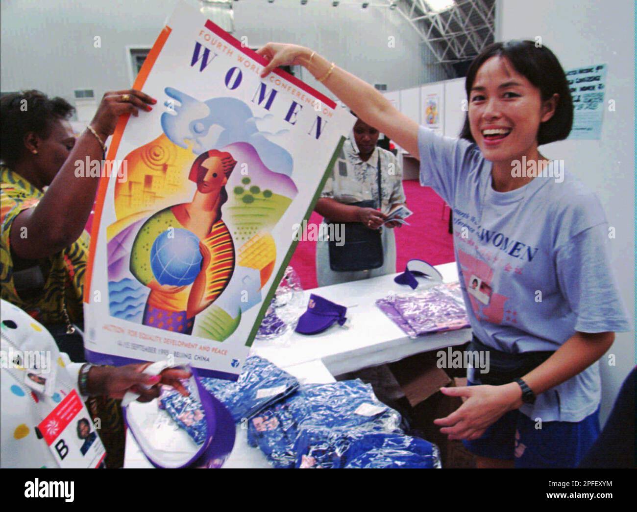 A Chinese volunteer hands out a copy of the official poster for the ...