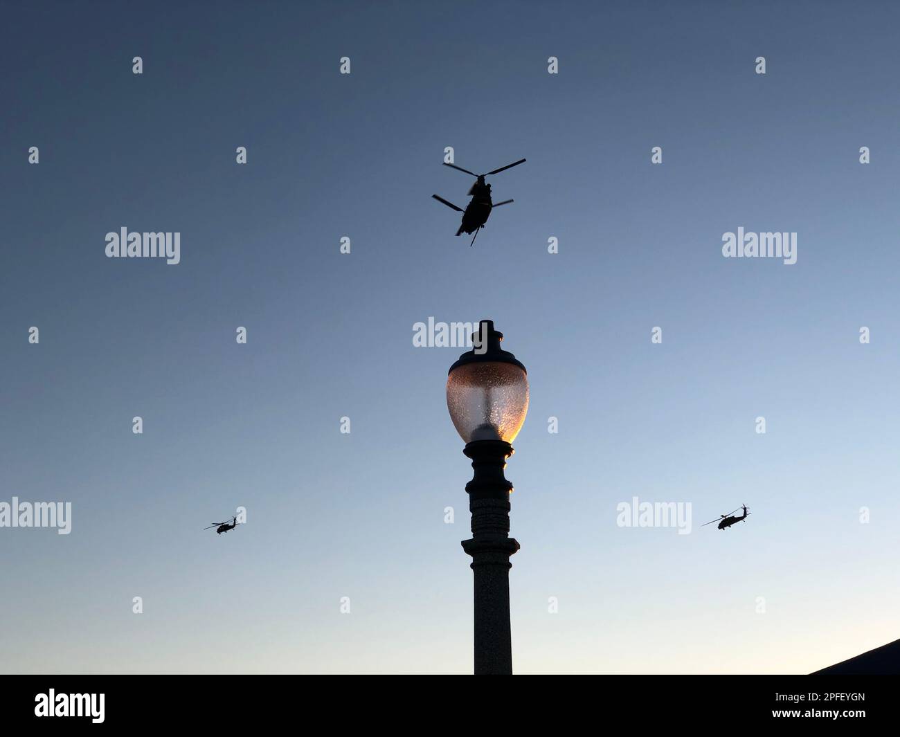 Helicopters flying over a light pole Stock Photo - Alamy