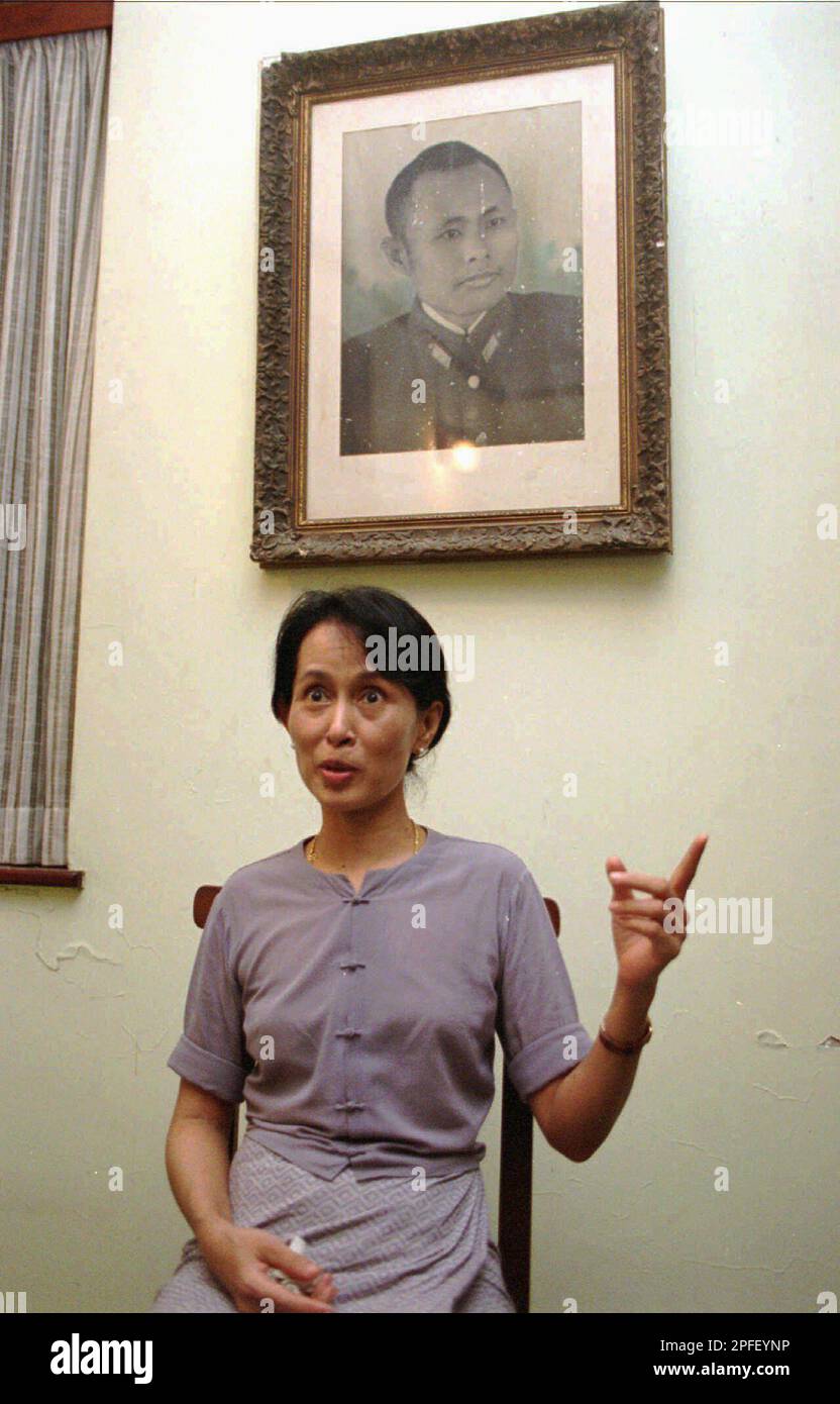 Nobel Peace Prize winner Aung San Suu Kyi sits under a photograph of ...