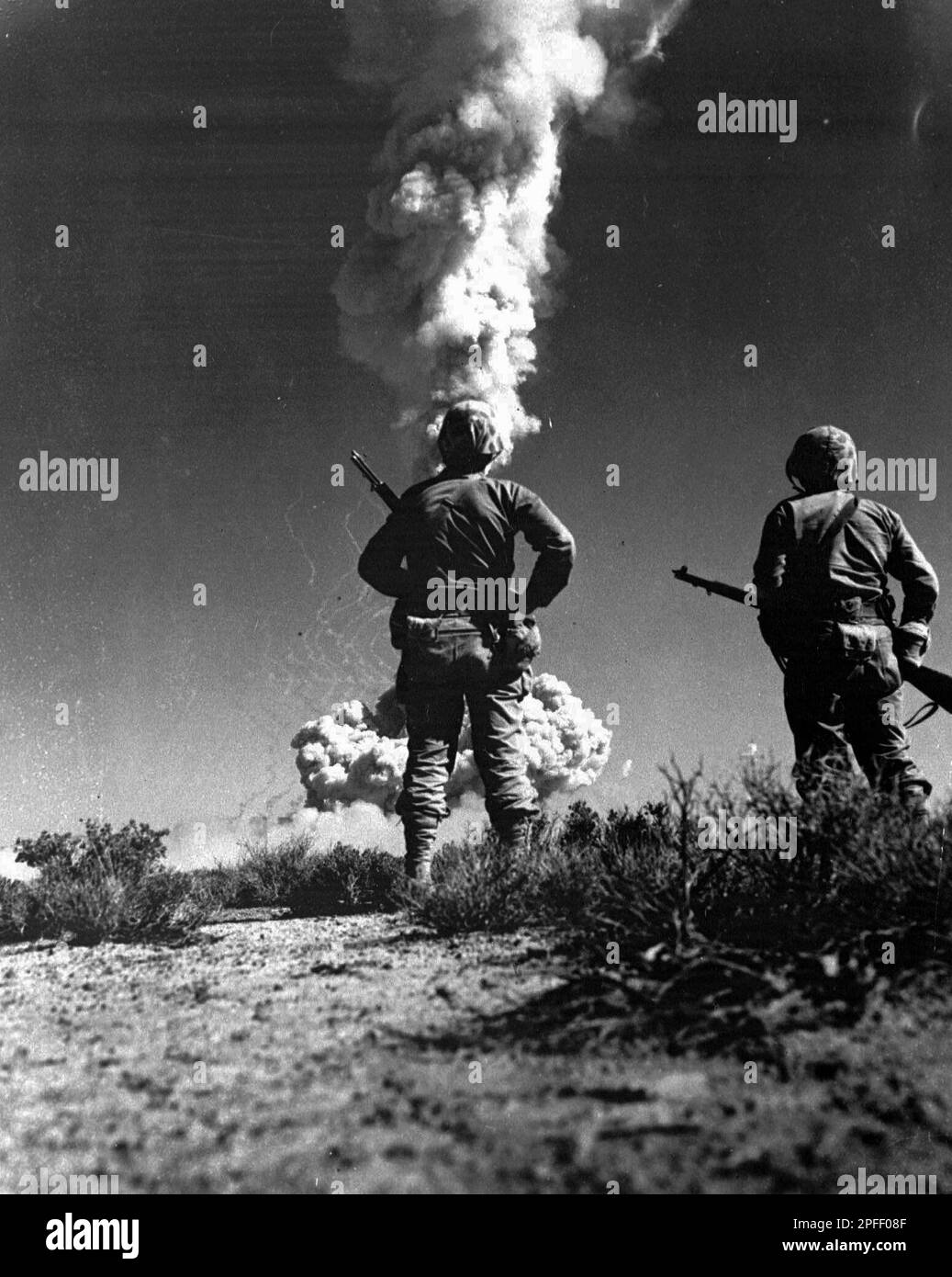 FILE--Two soldiers look at an atomic cloud during a nuclear bomb ...