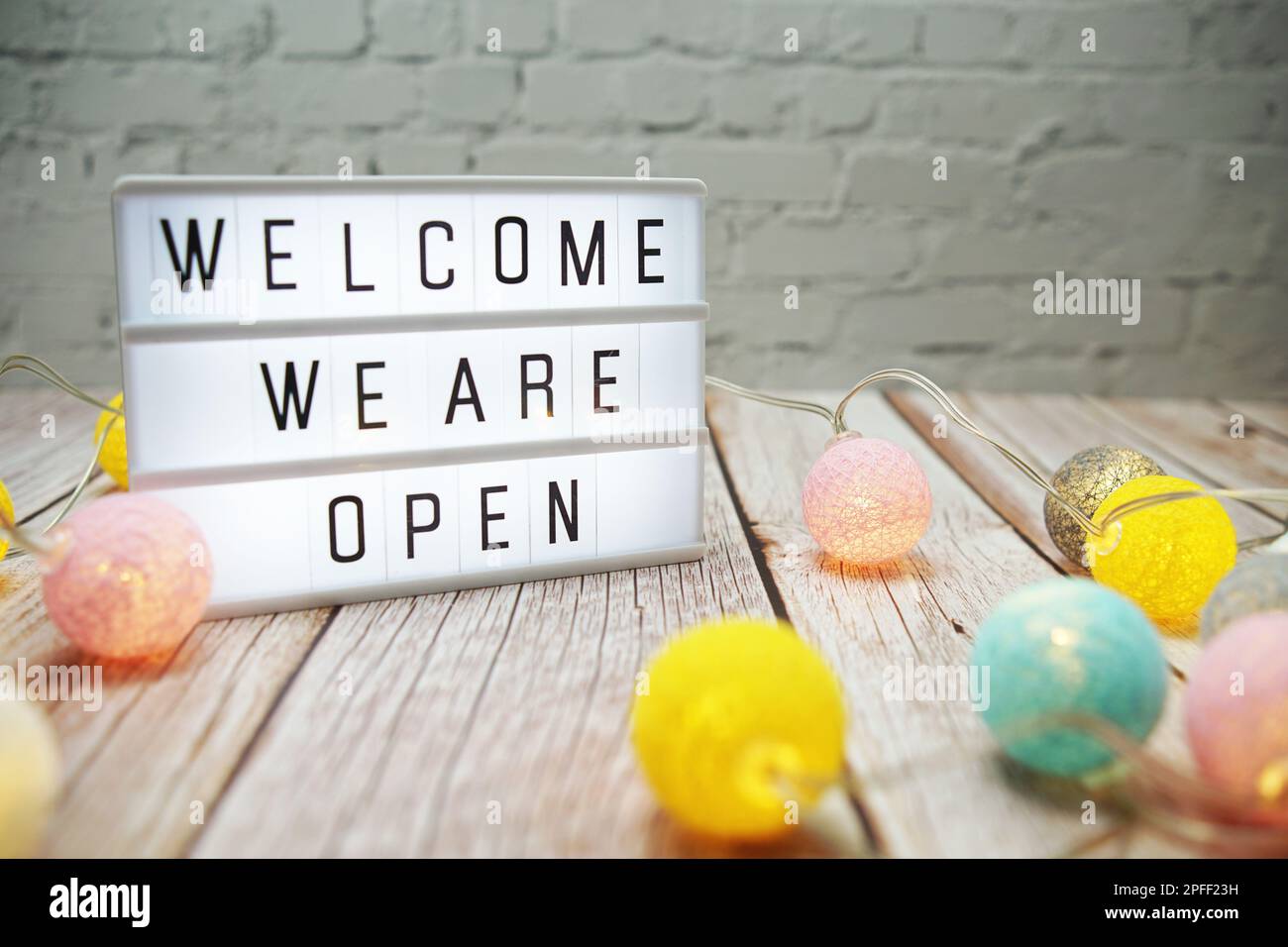 Welcome We are Open text on lightbox on wooden background Stock Photo ...