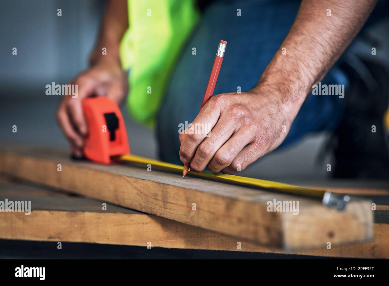 No margin of error here. a young builder using a measuring tape at a ...