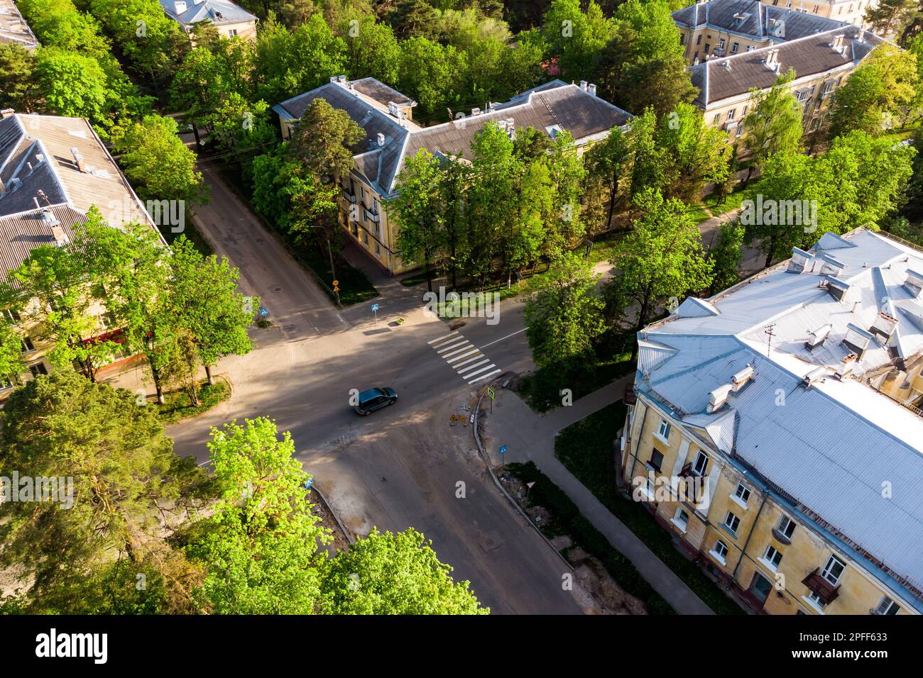 Aerial view of a highway intersection in a city surrounded by green ...