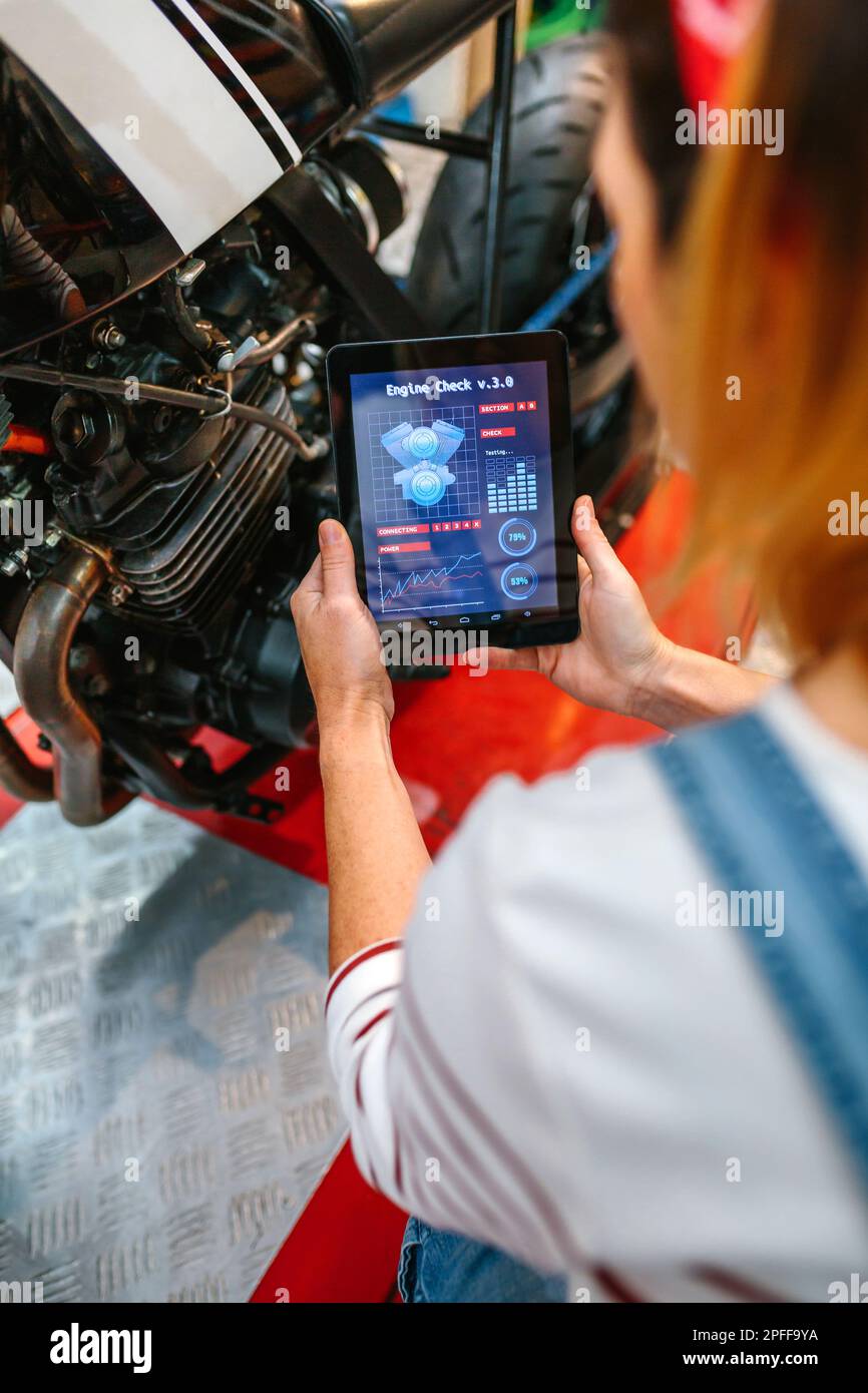 Mechanic woman using engine diagnosis app to review motorcycle Stock ...