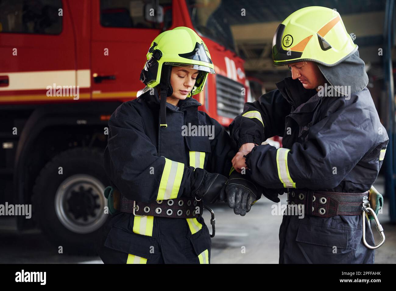 Male and female firefighters in protective uniform standing together ...