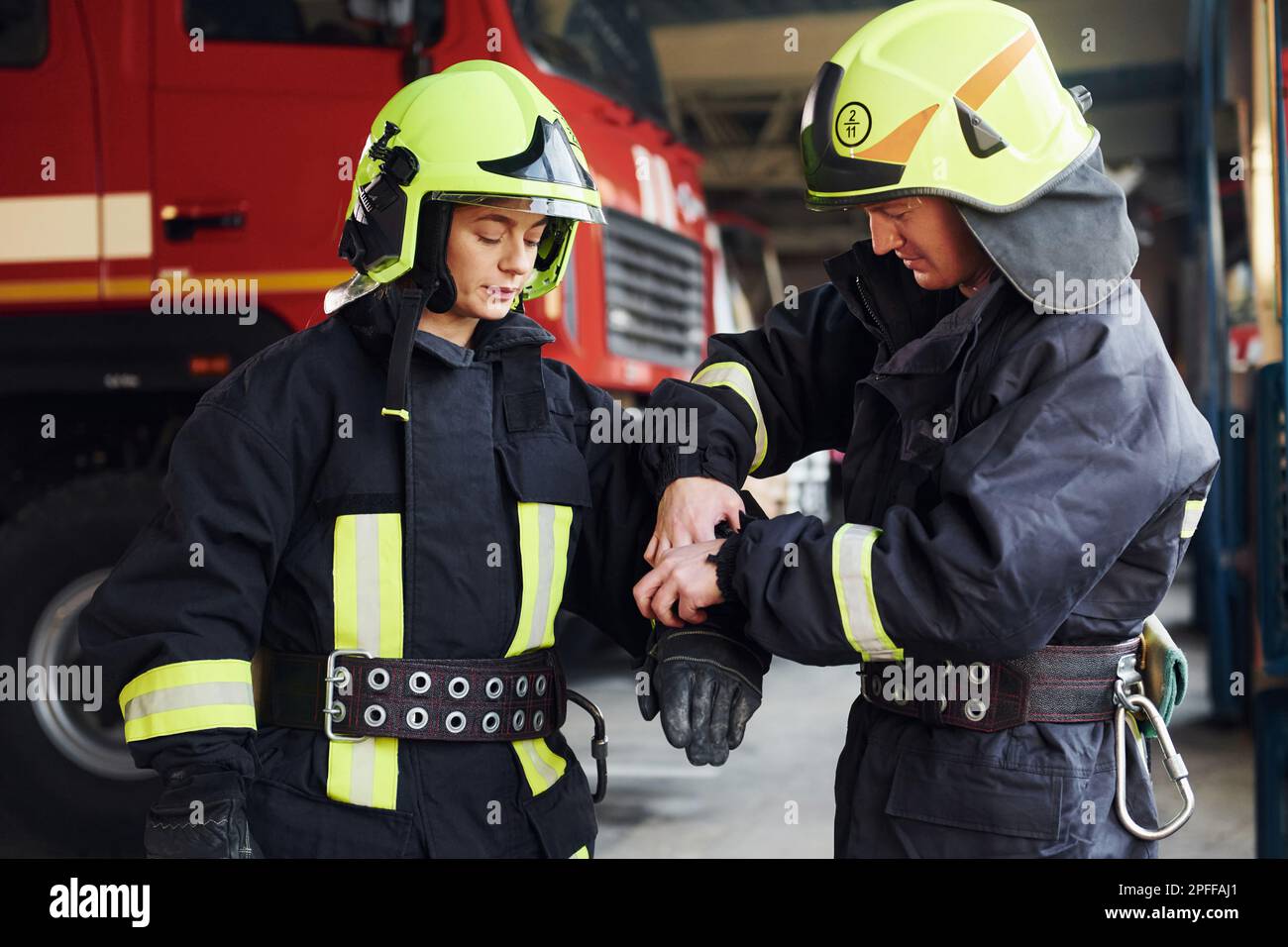 Male and female firefighters in protective uniform standing together ...