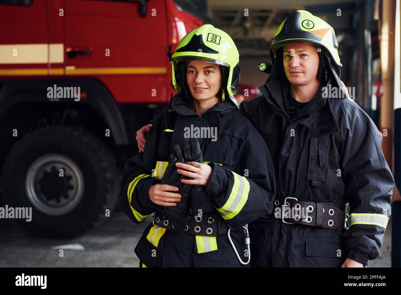 Male and female firefighters in protective uniform standing together ...