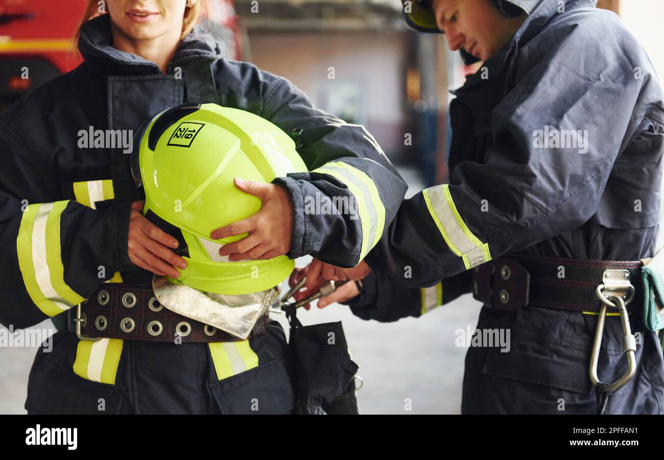 Male and female firefighters in protective uniform standing together ...