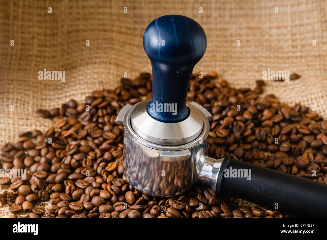 Coffee whole roasted beans background with metal and wooden holder and ...