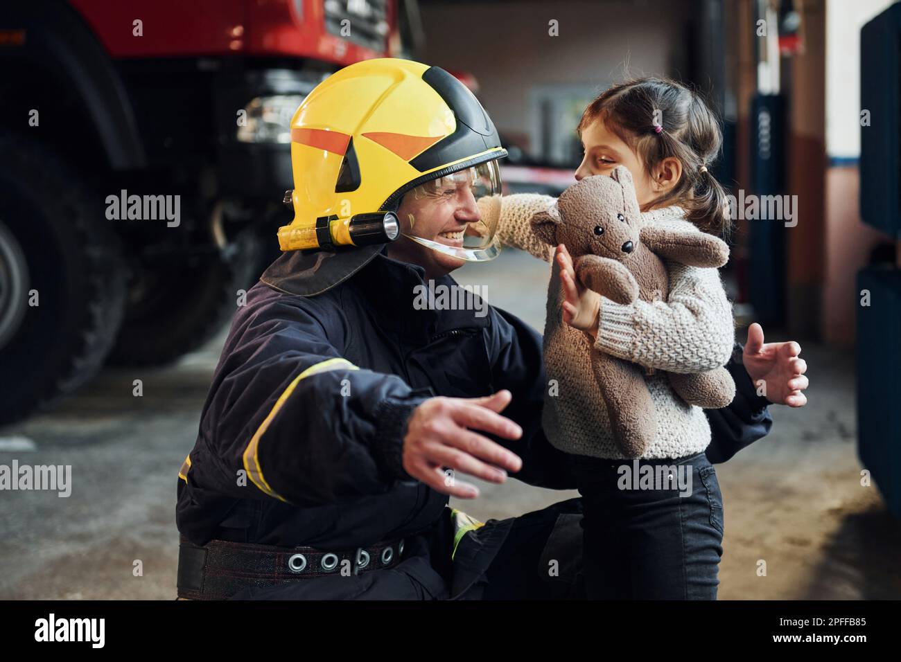 Happy little girl is with male firefighter in protective uniform Stock ...