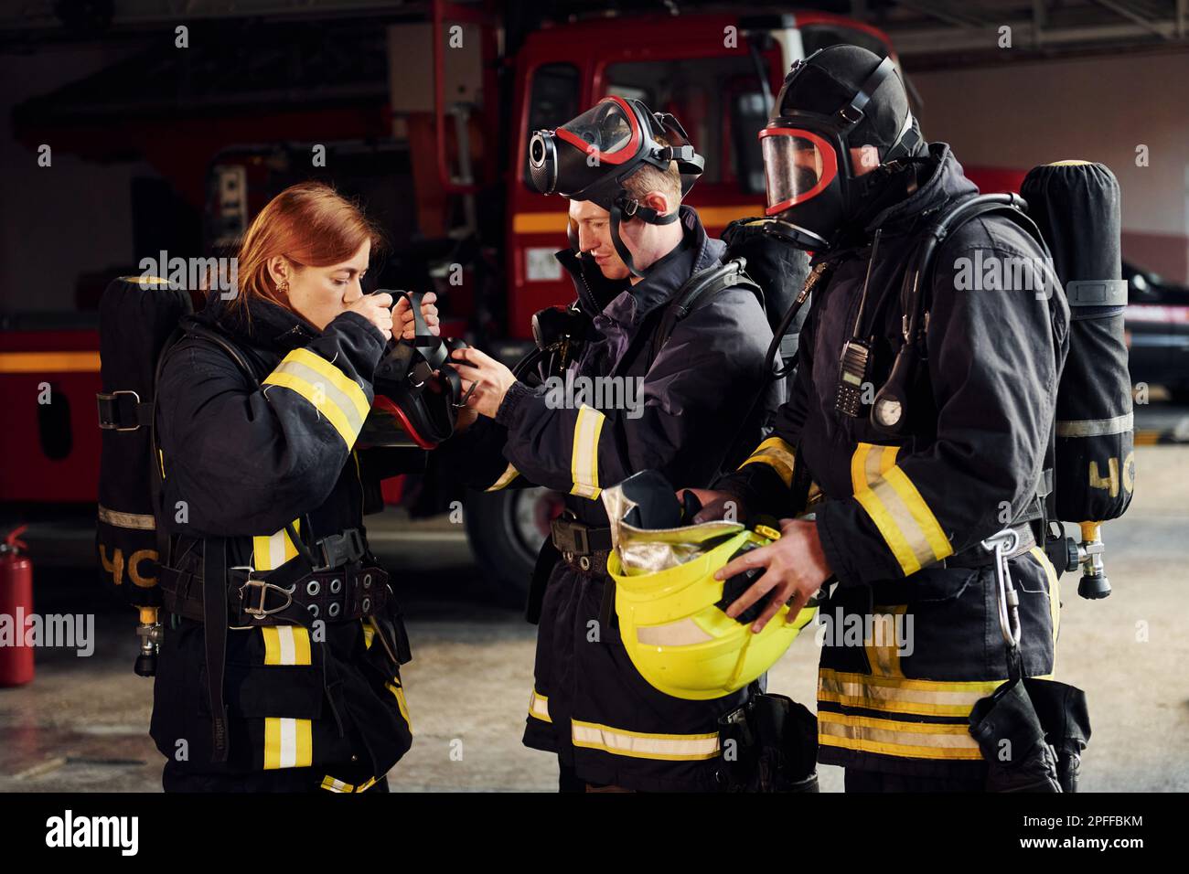Wearing protective uniform. Group of firefighters that is on station ...