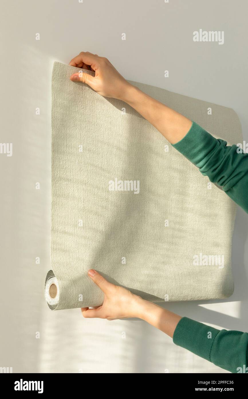 DIY interior hand motion, closeup repaper wallpaper Stock Photo - Alamy