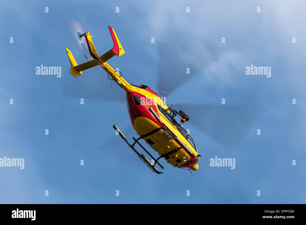 Yellow and Red Airbus EC145 helicopter soaring through the sky Stock ...