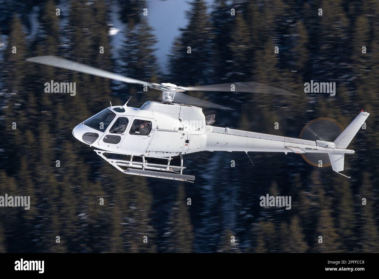 White Airbus Helicopters AS350 flying through the French Alps Stock ...