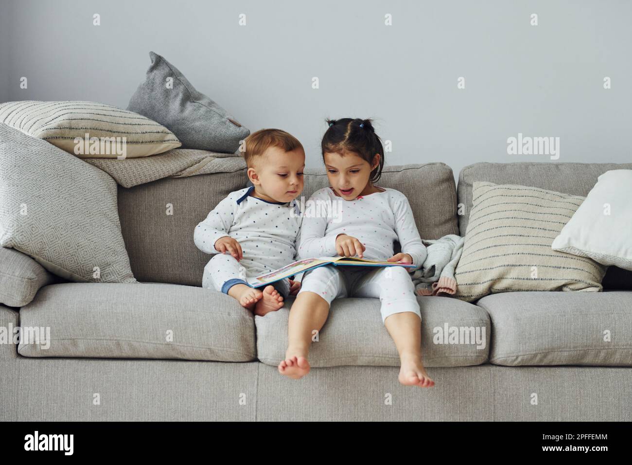 Sister and brother reading book. Interior and design of beautiful ...